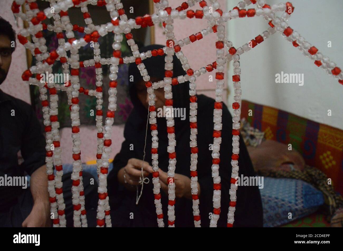 Peshawar, Pakistan. 26th Aug, 2020. Shia woman busy preparing Alam ...