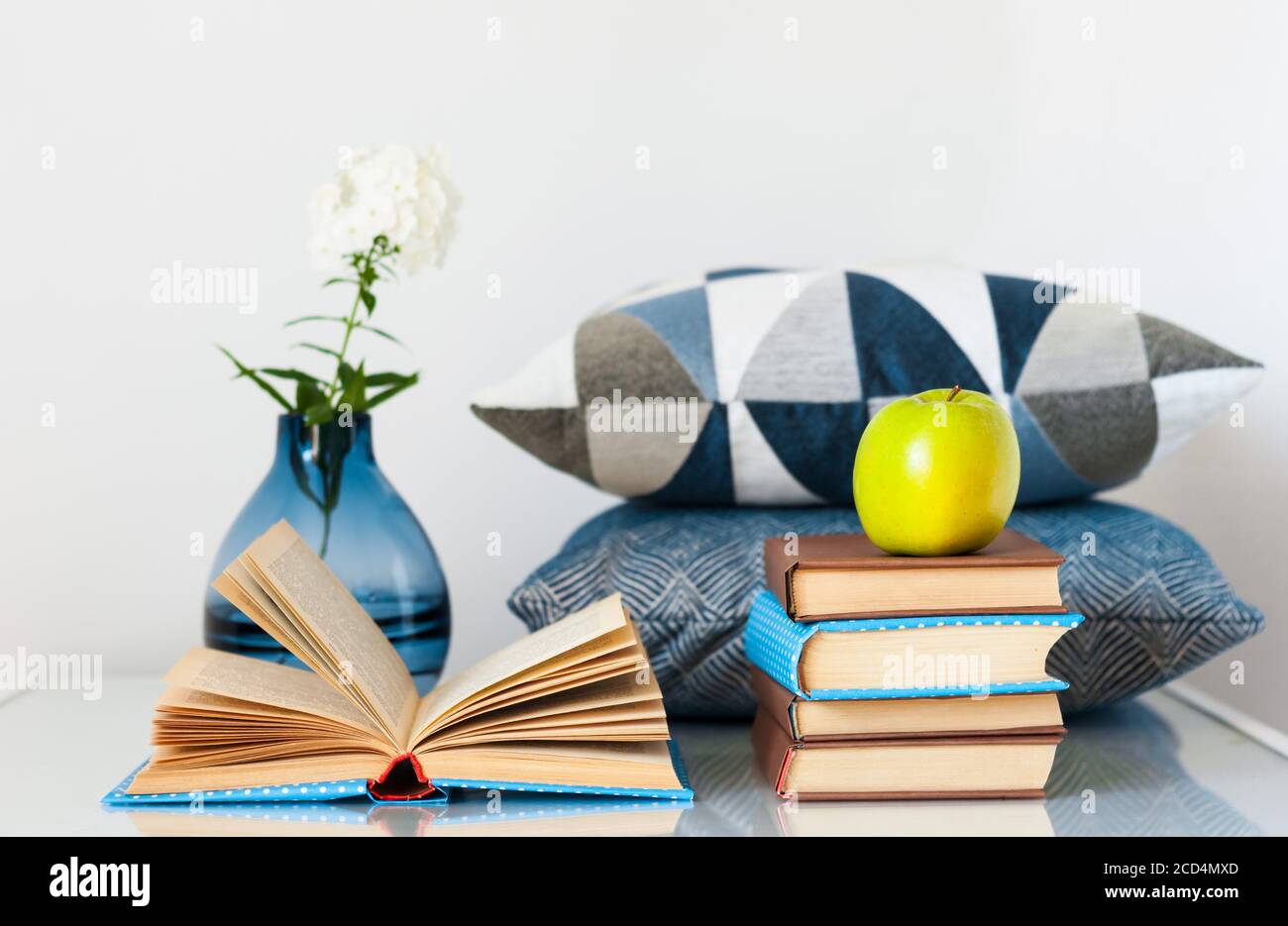 Cozy home interior decor: stack of books, green apple, decorative ...