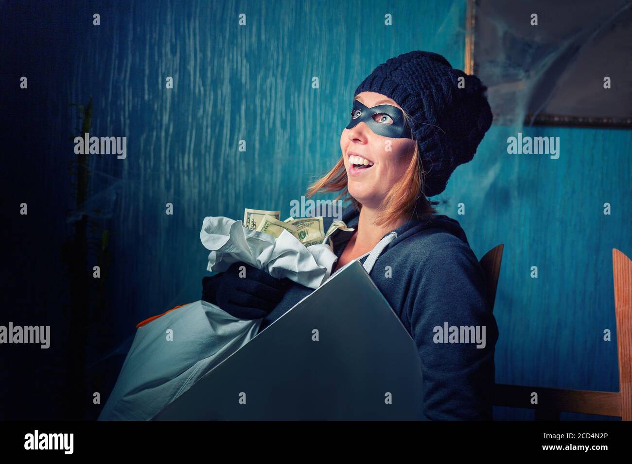 A masked female robber with a stolen bag of money in her hands looks ...
