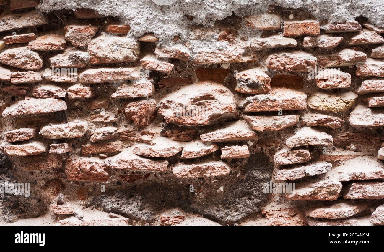 texture of a stone wall of an old building with crumbling plaster ...