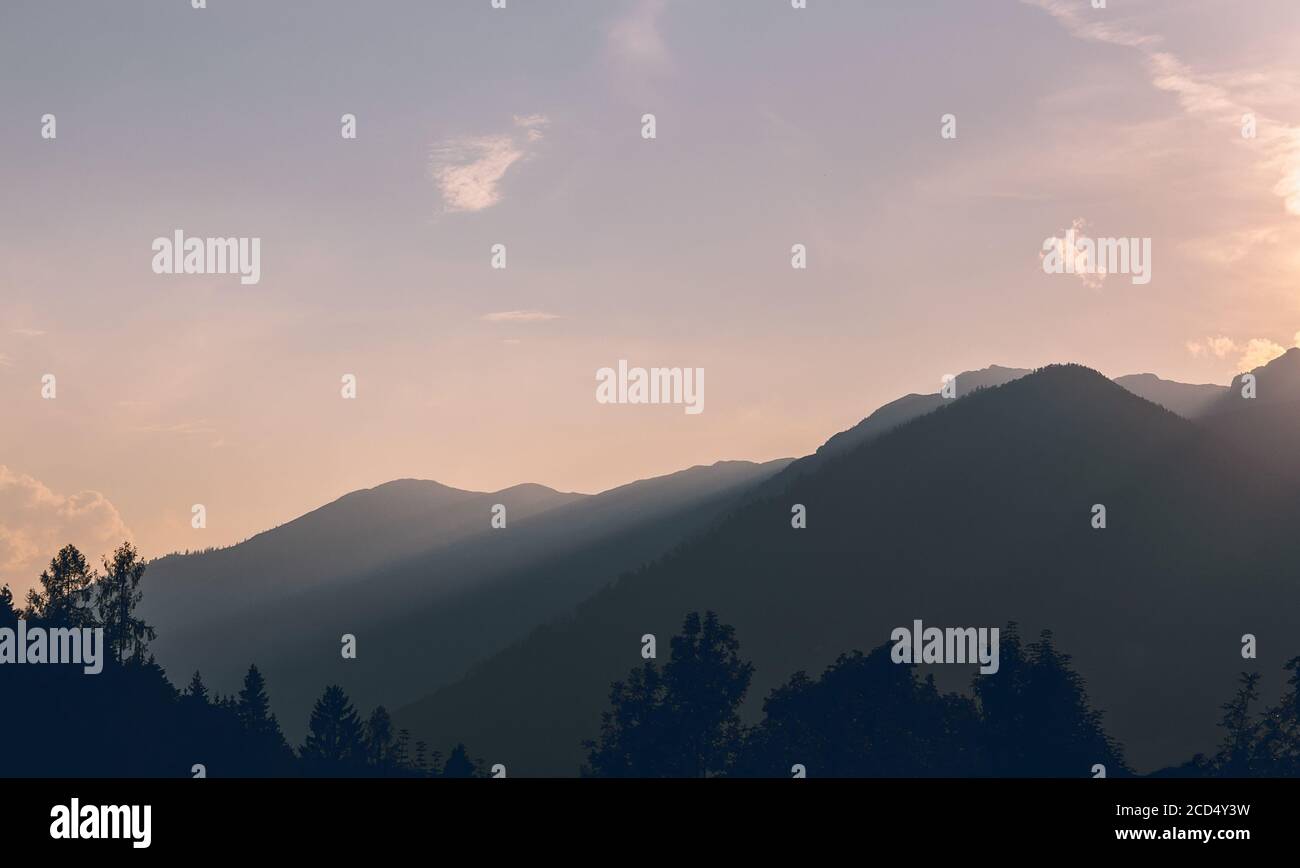 Alps mountain silhouette with trees and sunset sky. Austria landscape ...