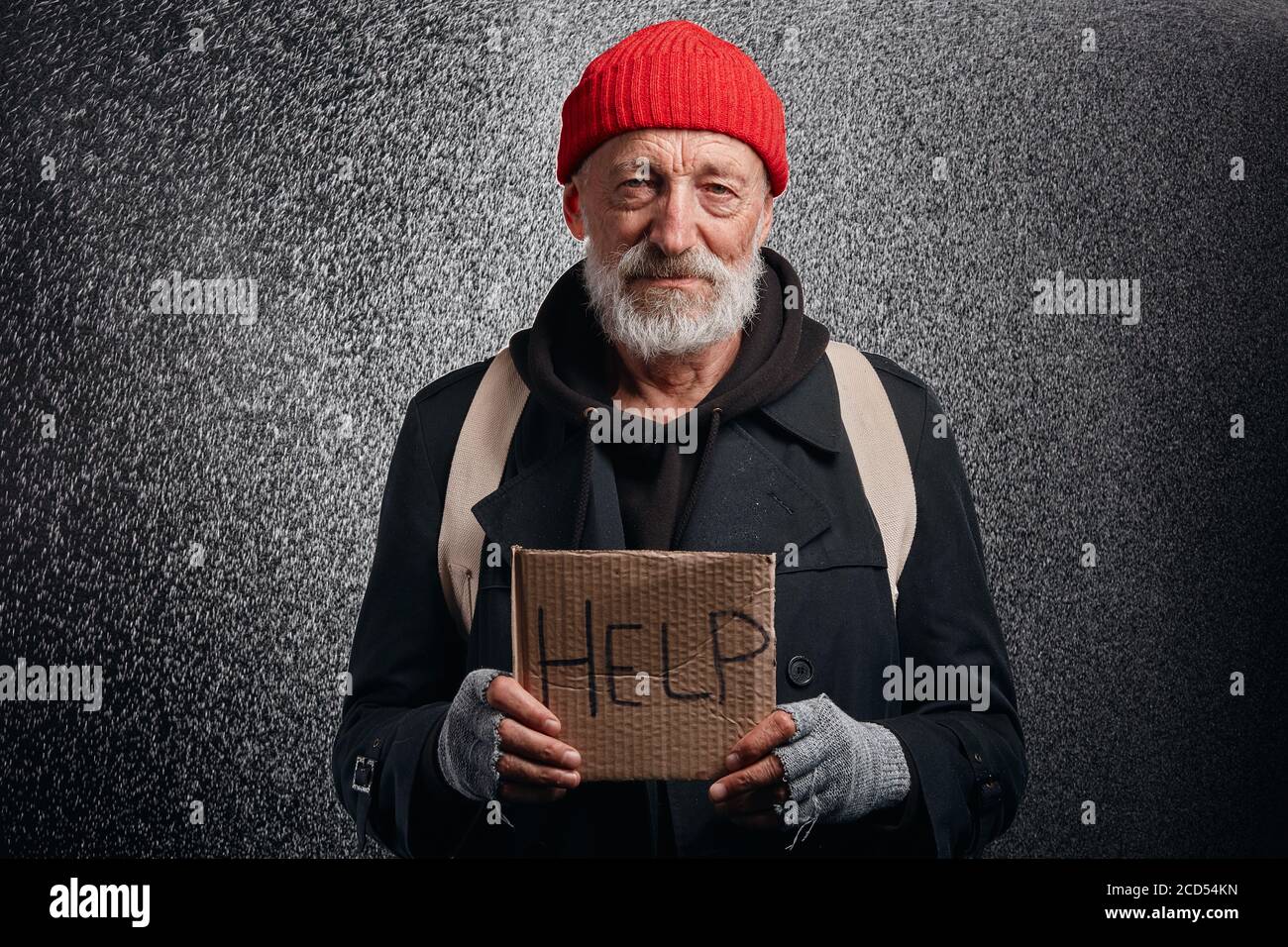 Mature vagabond man with grey beard stand showing a sign to everyone ...