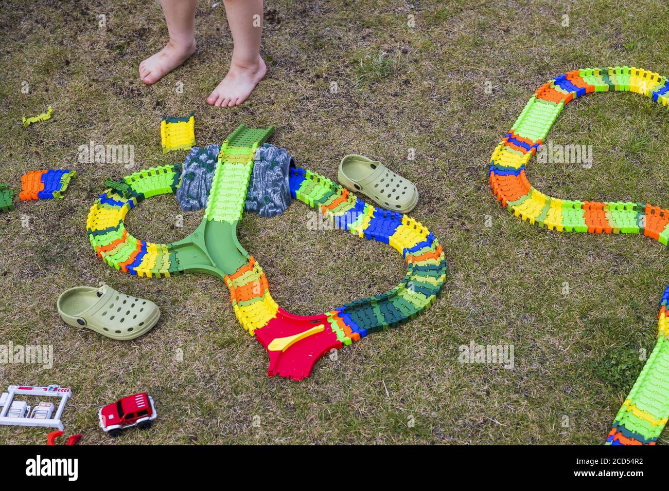 View of child playing with a colorful set of toy car race track in the ...