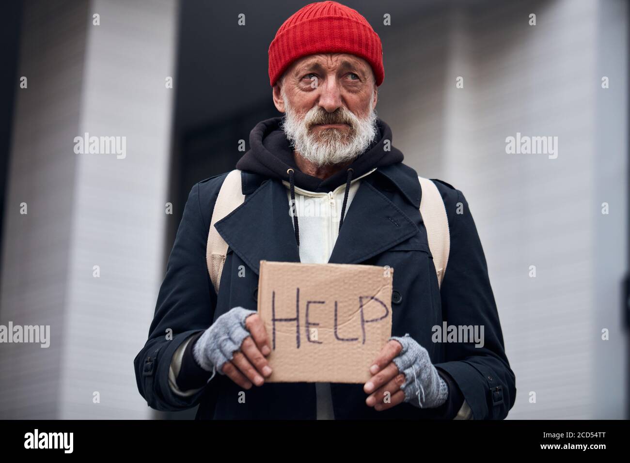 Poor man holding help sign made by cardboard, stand in the center of ...