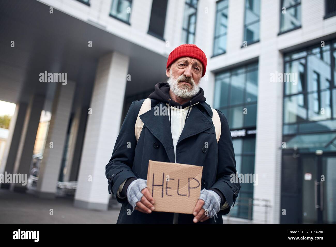 Poor man holding help sign made by cardboard, stand in the center of ...