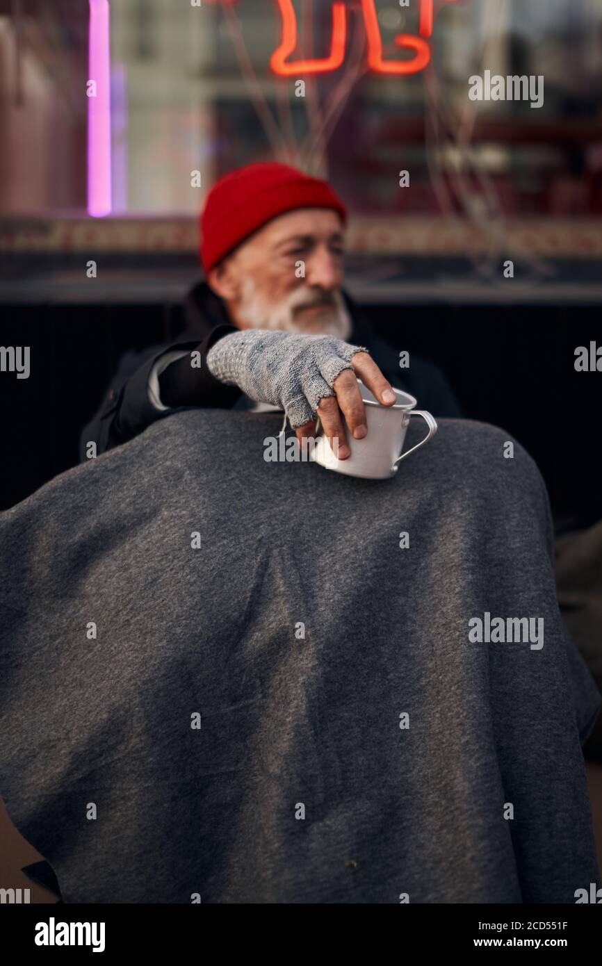 Pity poor vagrant begging in the center of city, sitting on the floor ...