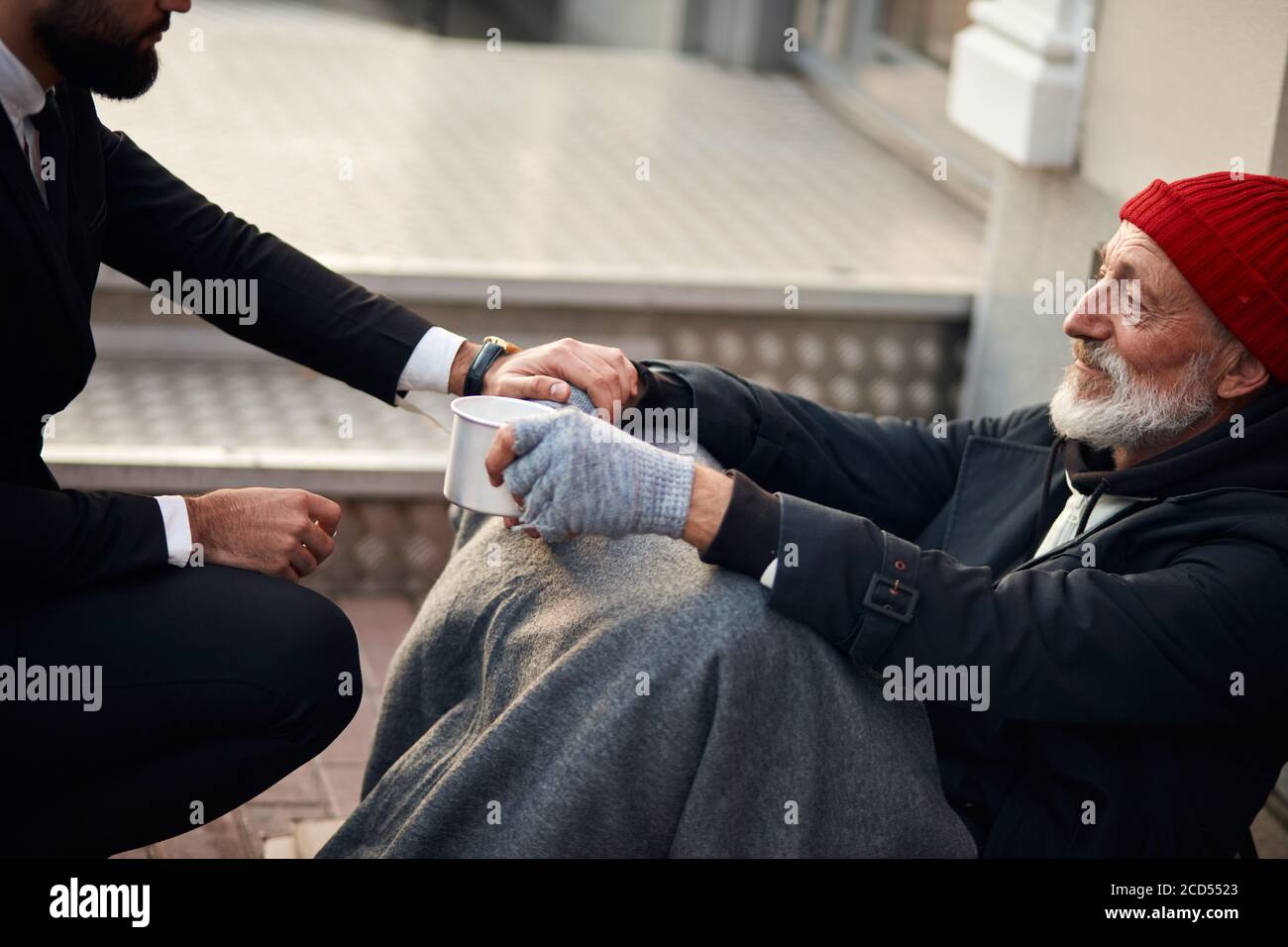 Kind man help beggar male sitting on street begging, cold weather. Pity ...