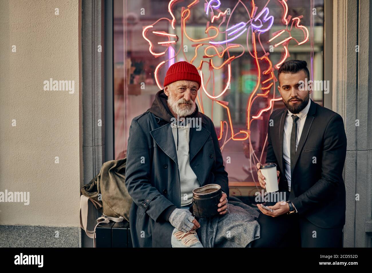 Rich man in tuxedo and homeless person in dirty clothes sitting and ...