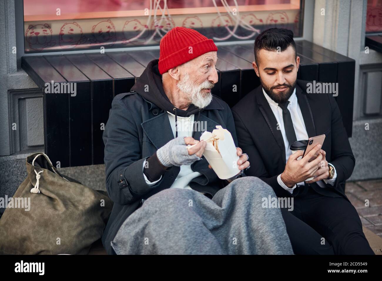 Rich man in black suit sit with phone, show interesting videos while ...