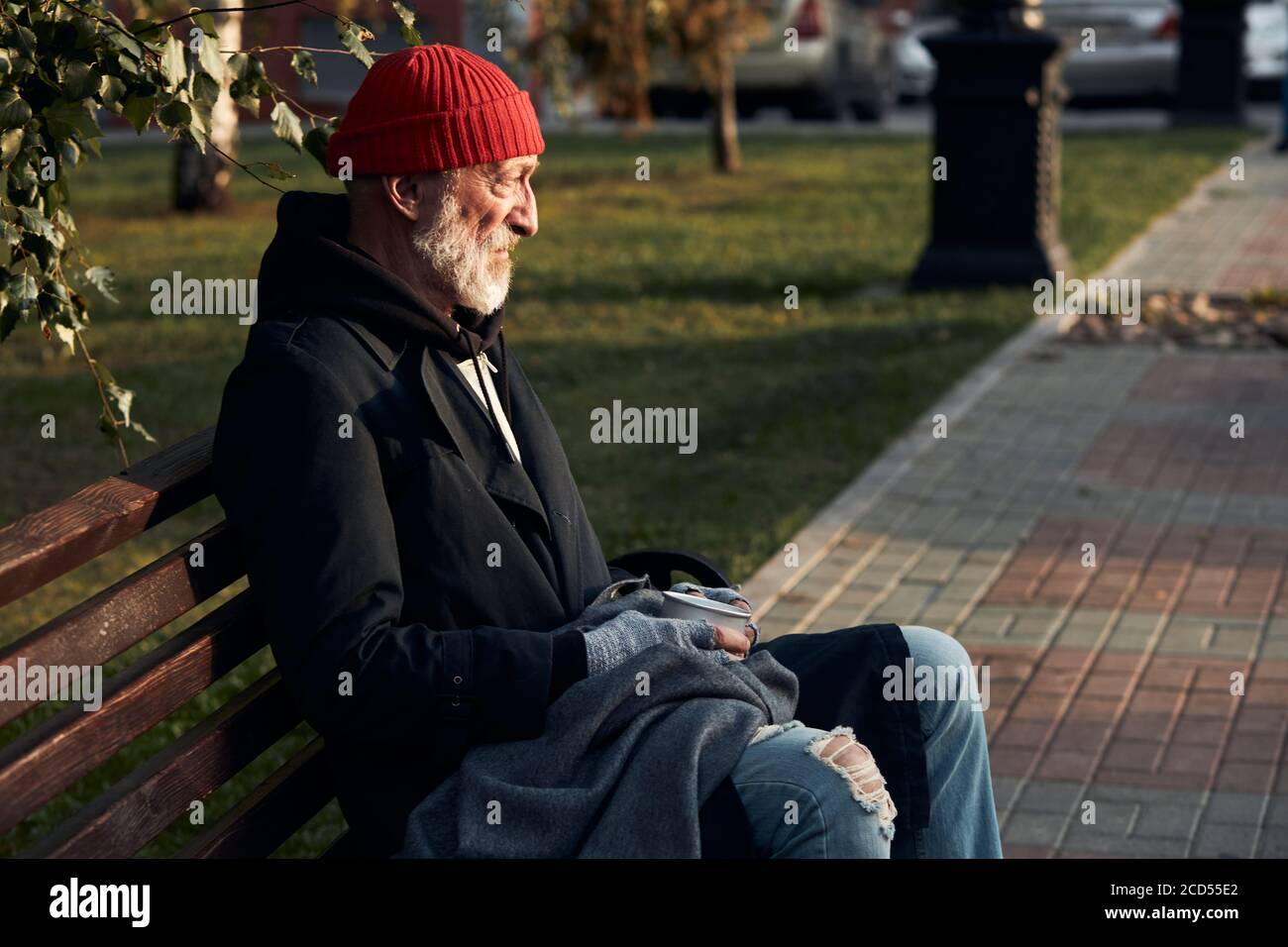 Mature man without shelter sitting in street clothes on bench, without ...