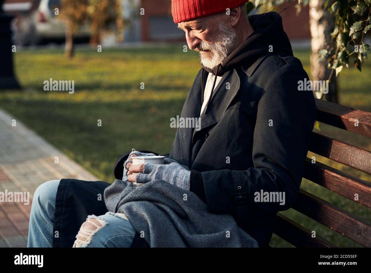 Mature man without shelter sitting in street clothes on bench, without ...