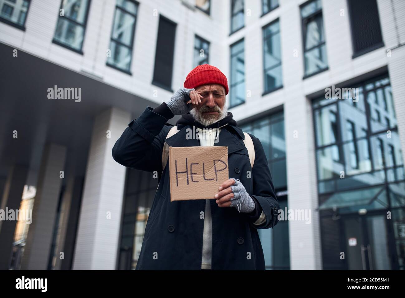 Crying man holding help sign made by cardboard, stand in the center of ...