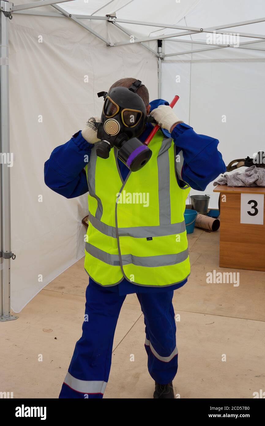 Worker puts on gas mask to protect against gas in emergency Stock Photo ...