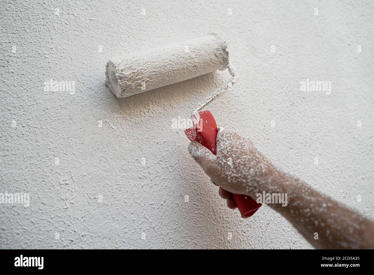 front view closeup of Caucasian male hand full of dirt painting an ...