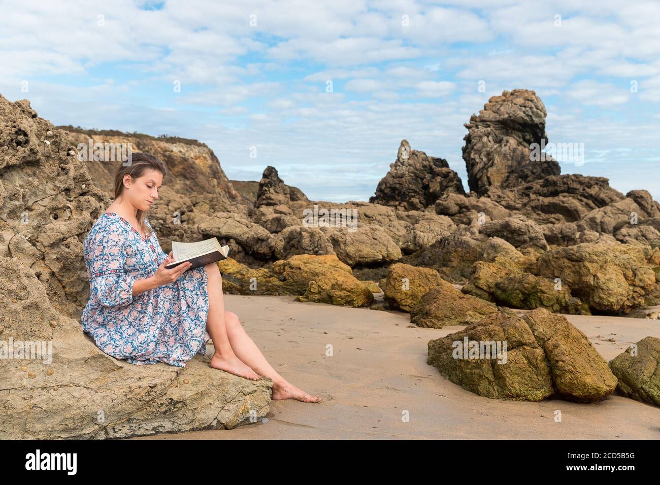 Girl sitting barefoot on rock hi-res stock photography and images - Alamy