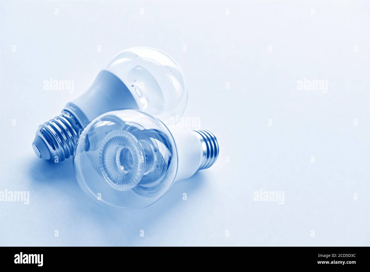 Two transparent LED light bulbs in monochrome blue. Energy saving ...