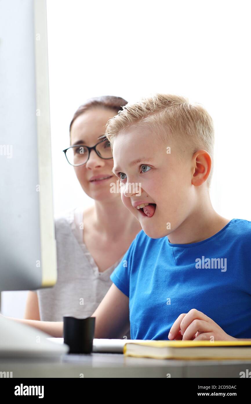 Home school, online learning. Mum helps the child learn online Stock ...