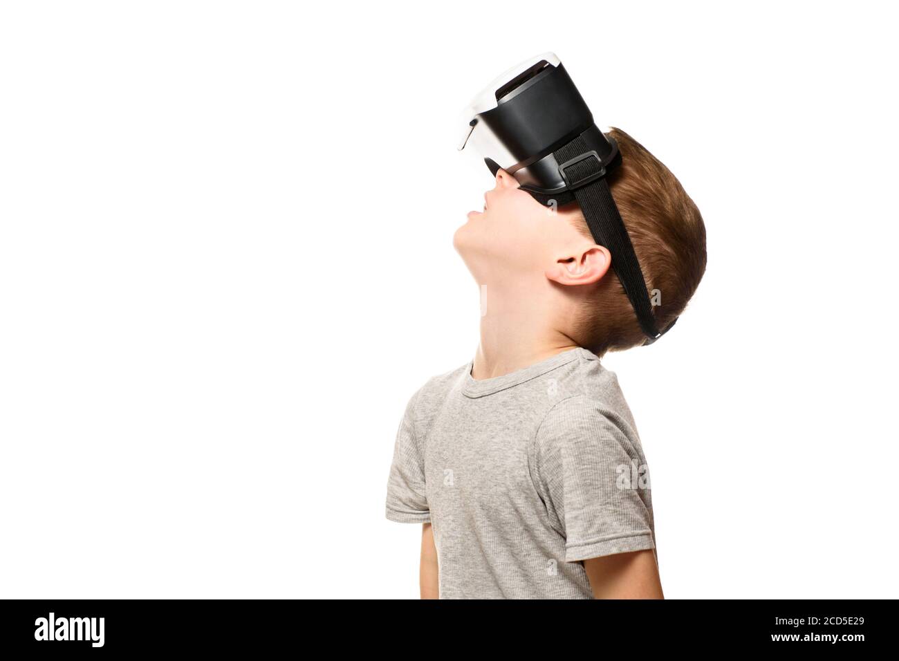 Boy experiencing virtual reality raising his head. Isolate on white ...