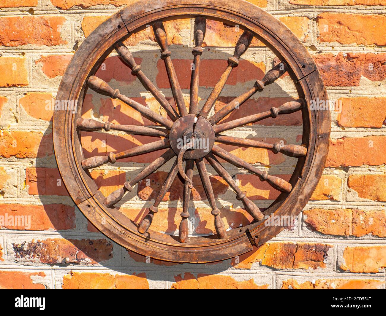 Old wooden wheel on a brick wall Stock Photo - Alamy