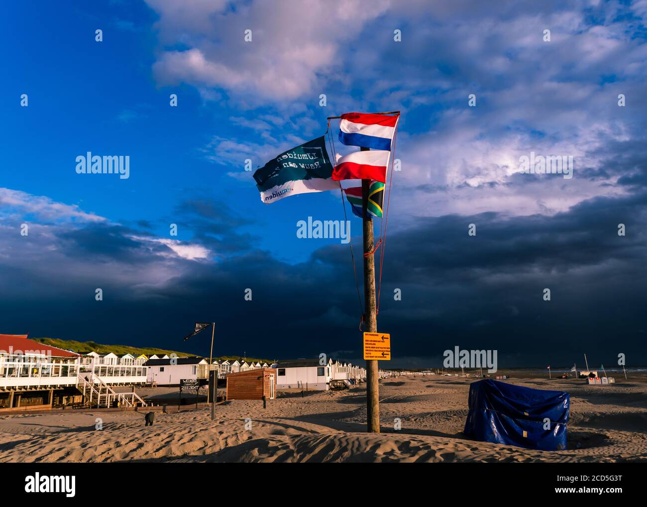 Wooden flagpole with the Polish, Dutch and the Brazilian flag. And the ...