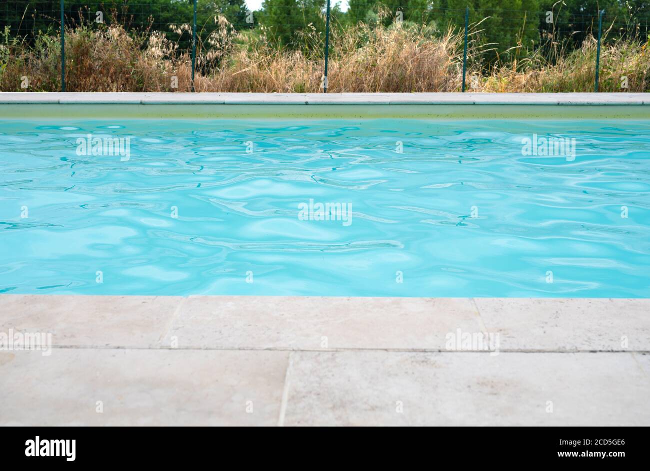 Section of swimming pool with stone surround Stock Photo - Alamy
