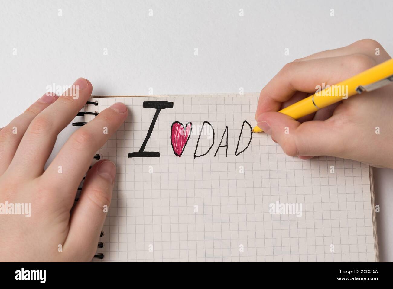 Child writes write I love dad. Father's day concept. Notepad on white ...