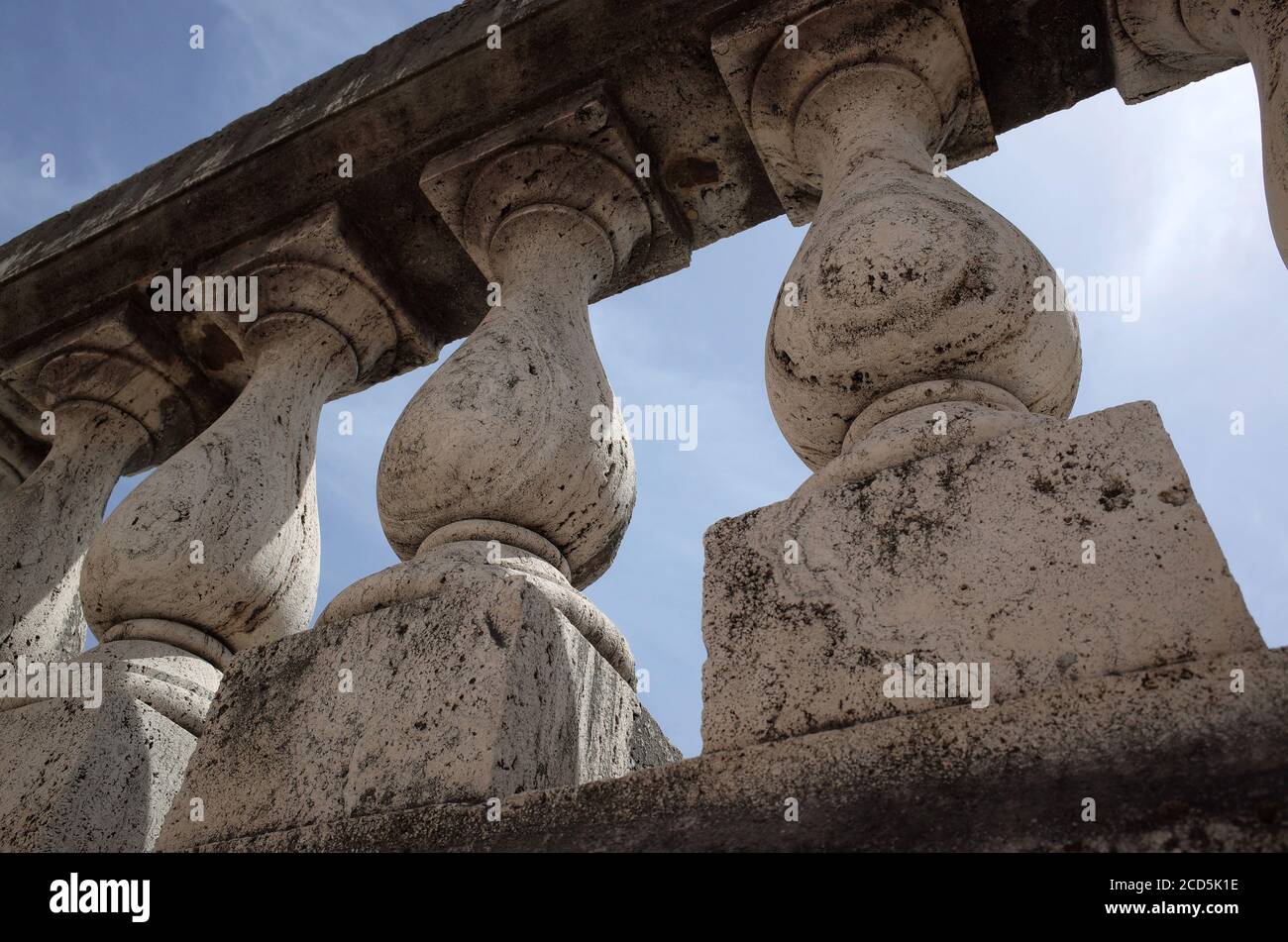 Old terrace balusters made of stone or concrete against blue sky ...