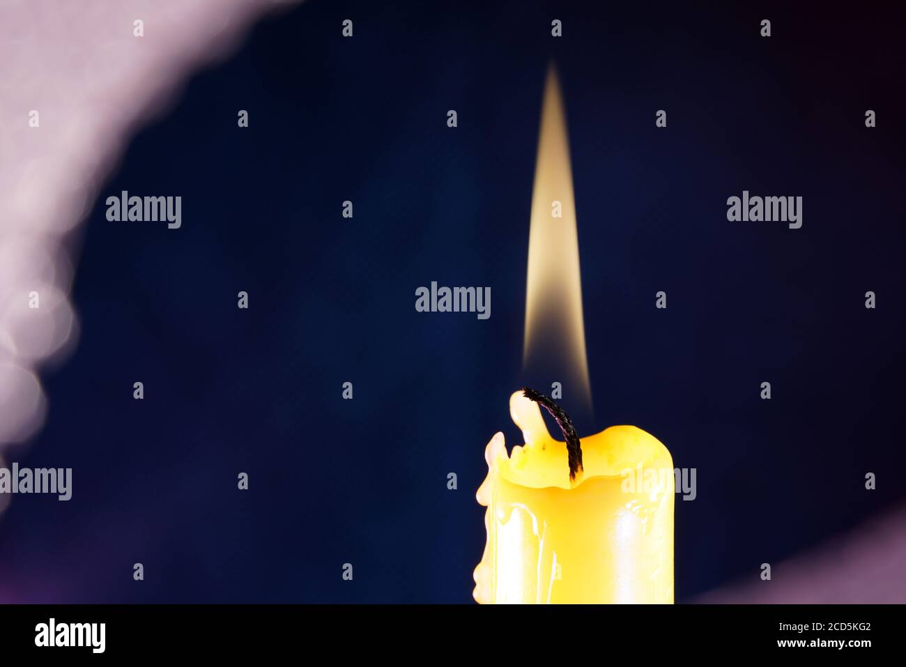 Closeup shot of a burning yellow candle on a dark background Stock ...
