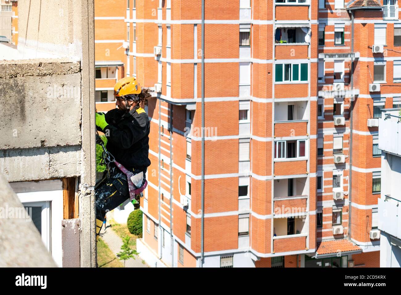 Male worker hanging on rope access and height construction project ...