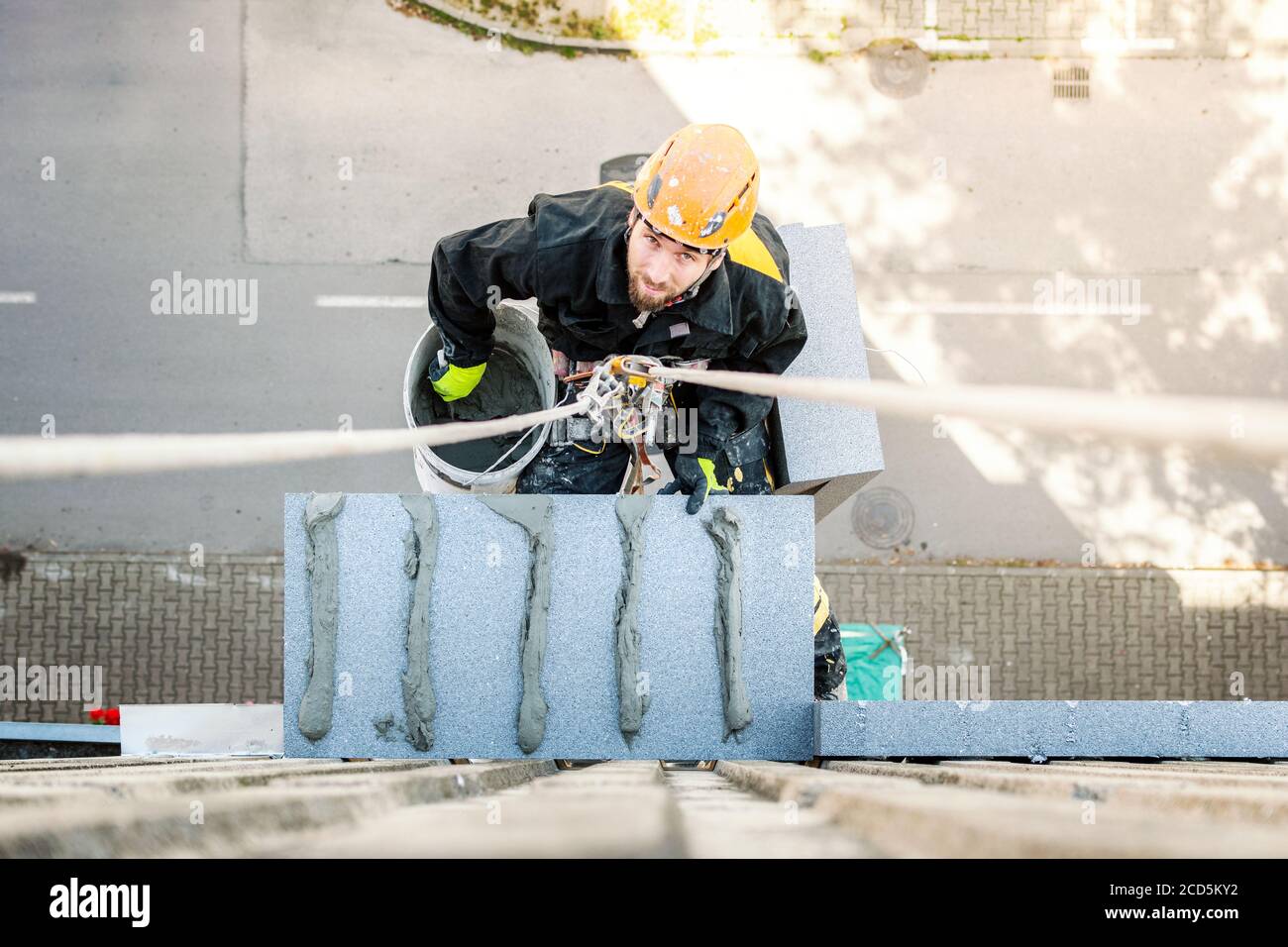 Male worker hanging on rope access and height construction project ...