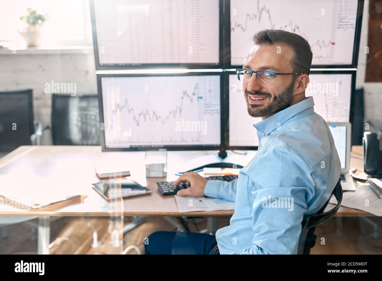 Stock Traiding. Trader sitting at office monitoring changes of ...