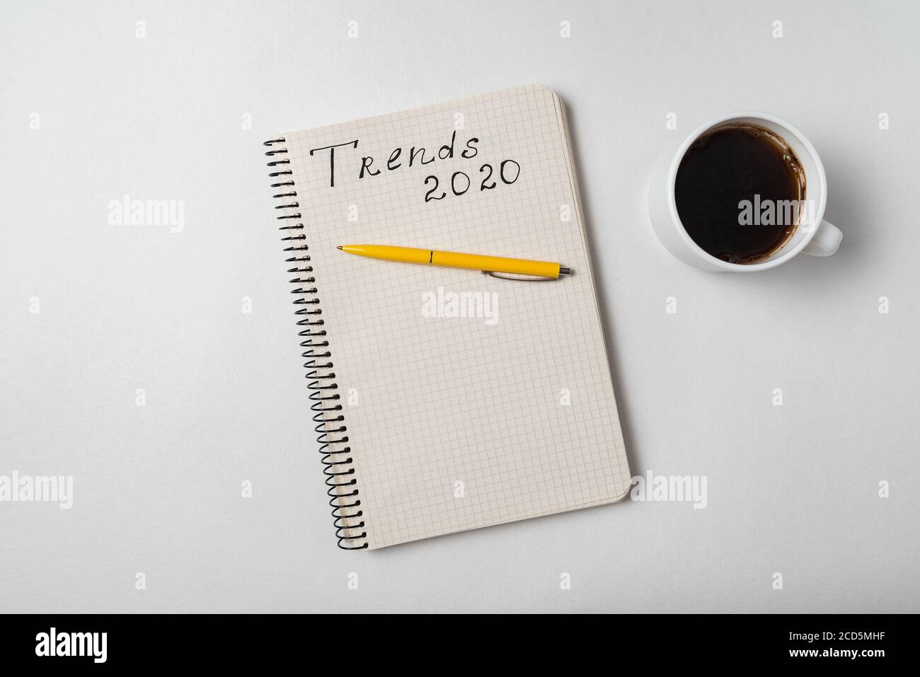 Trends 2020. Handwritten text. Notebook and Cup of coffee on white ...