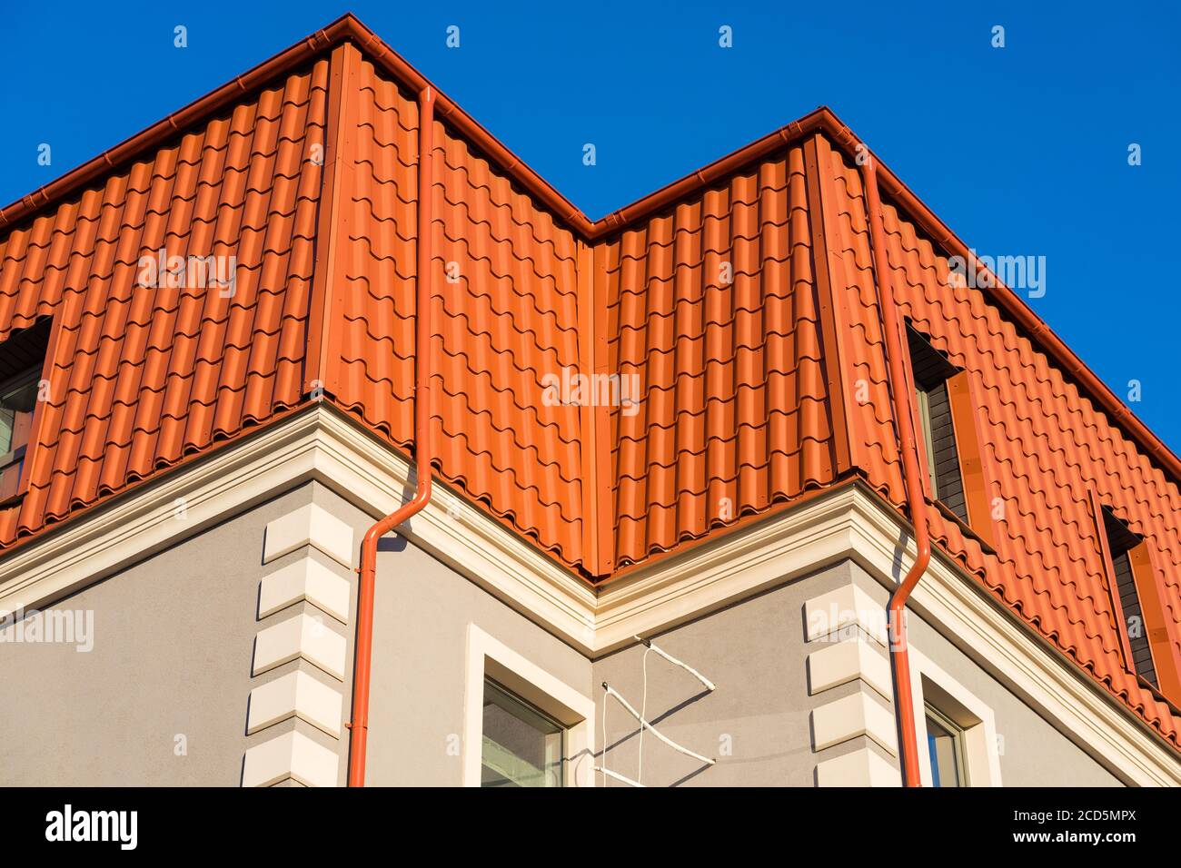 Newly installed construction frame house rain gutter system on the red ...