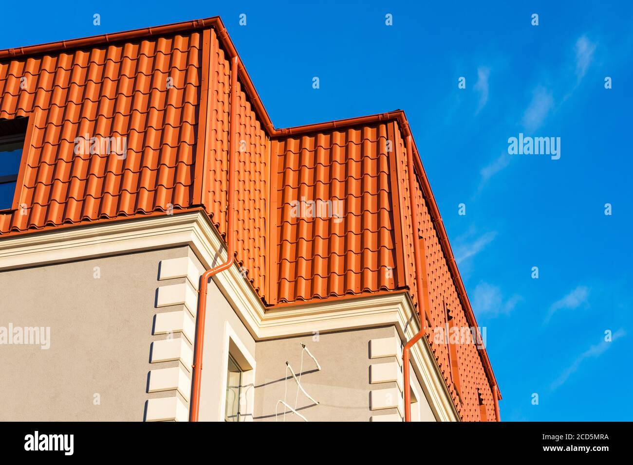 Newly installed construction frame house rain gutter system on the red ...