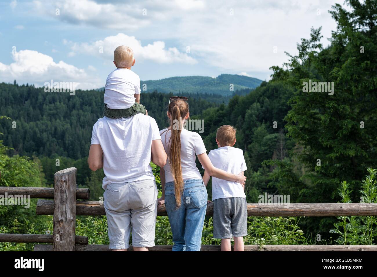 Family of four on nature background. Back view. Active rest Stock Photo ...