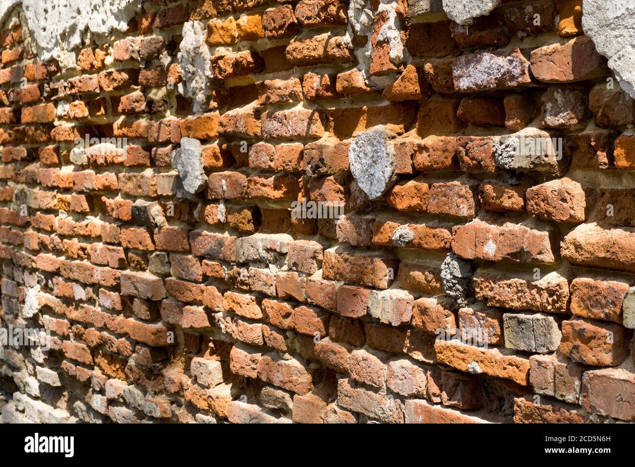 Dilapidated with potholes old brick wall of the building, made of red ...