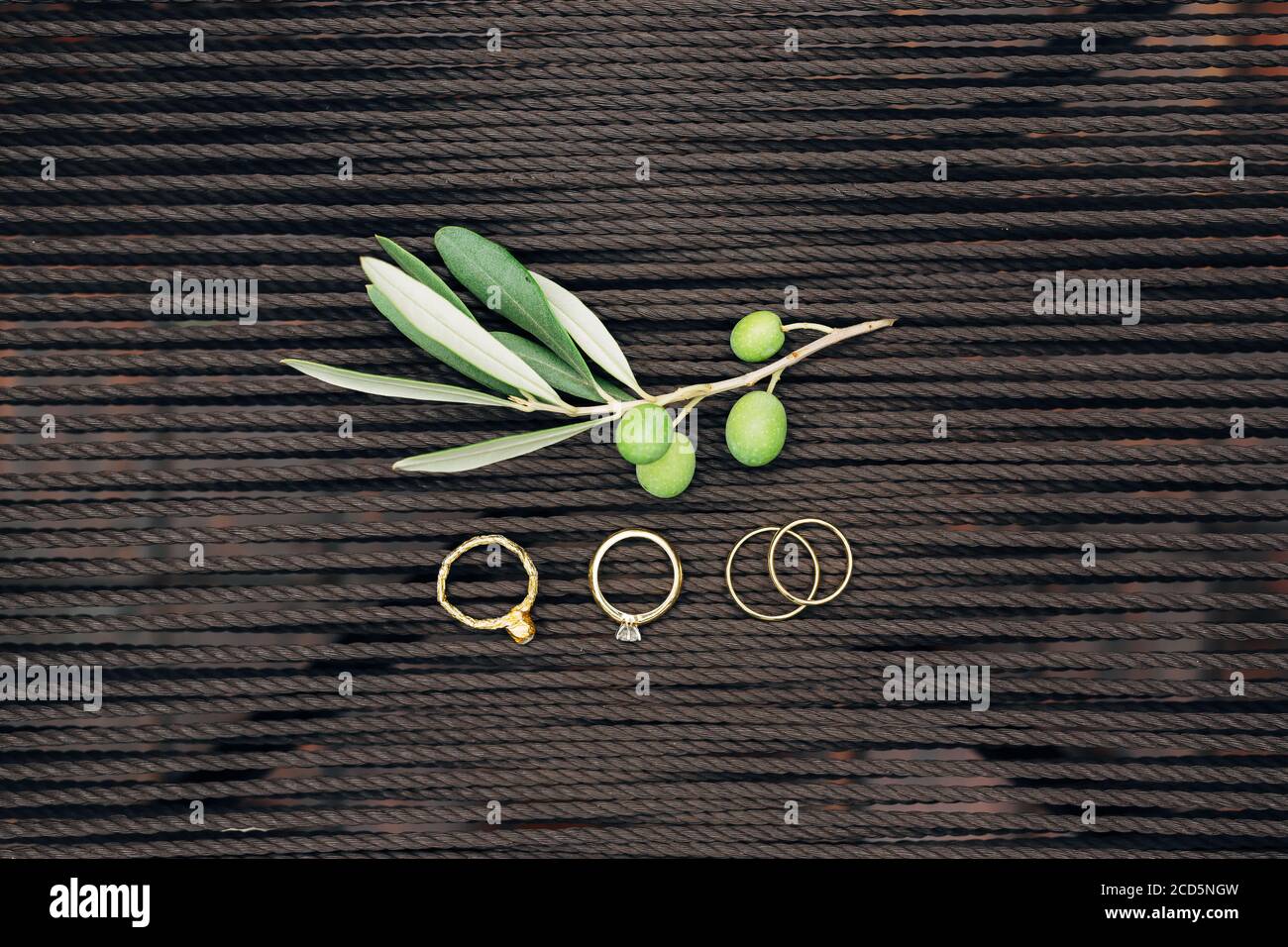 Gold wedding rings, an engagement ring and a foil ring with an olive ...