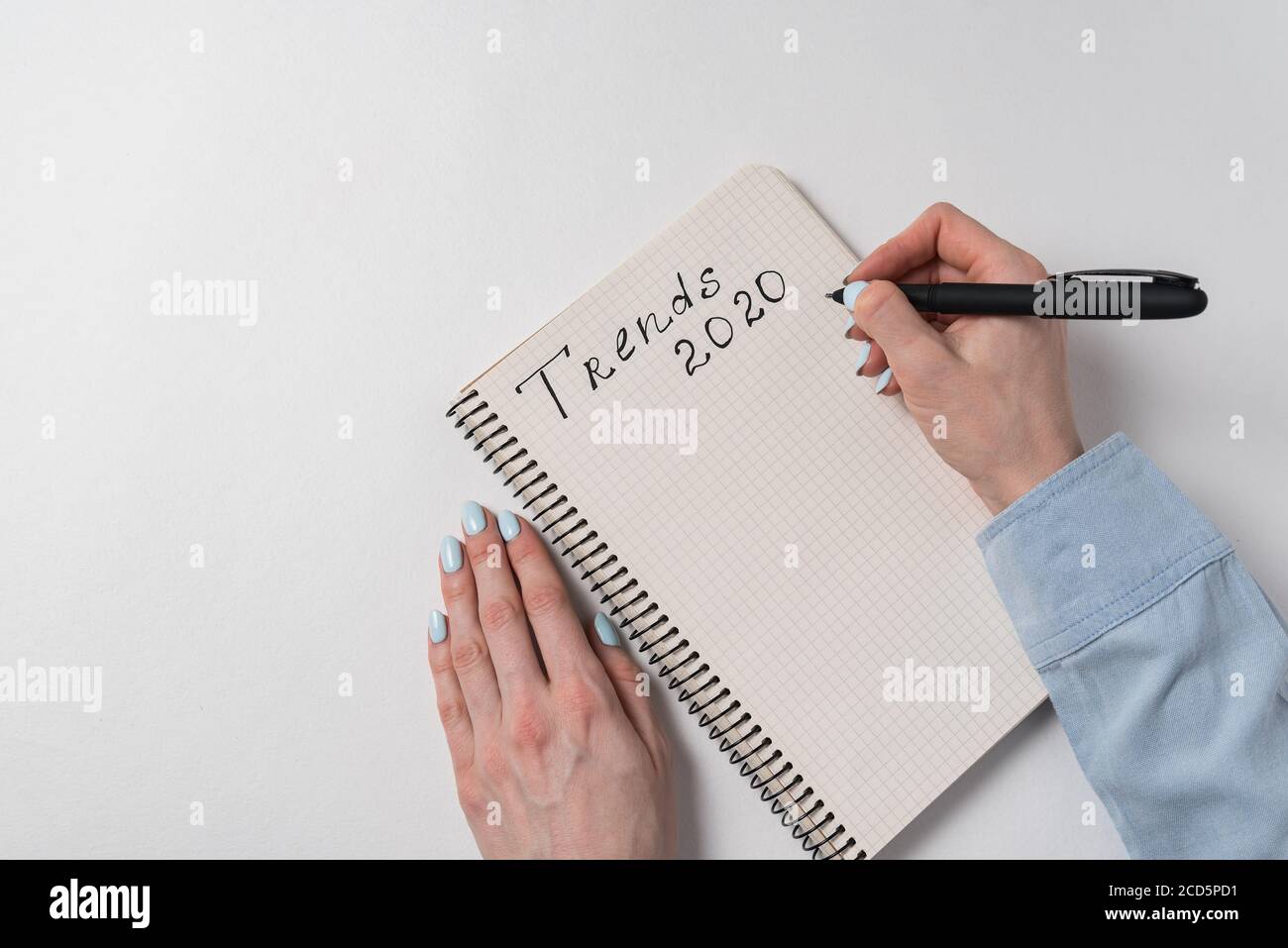 Trends 2020 handwritten text on copybook. Female hand writing in ...