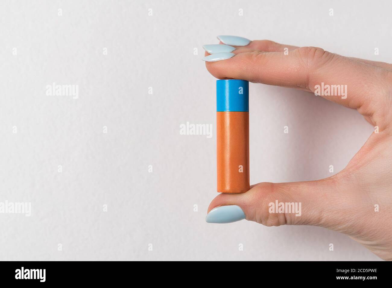 Female hand holding AA battery on white background. Accumulator Copy ...