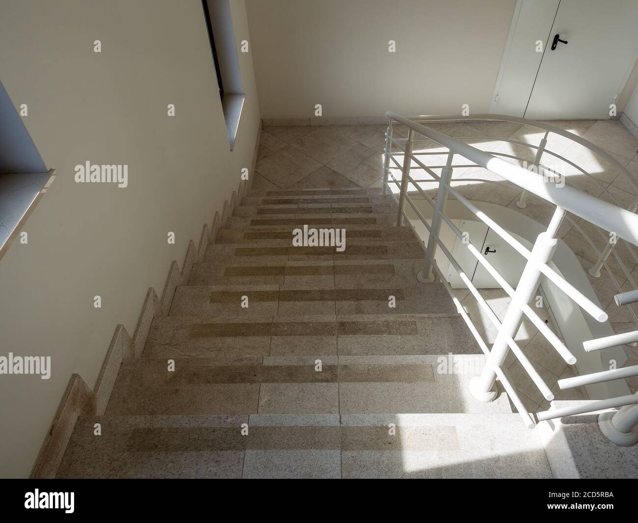 White corridor with marble steps leading down to the doors Stock Photo ...