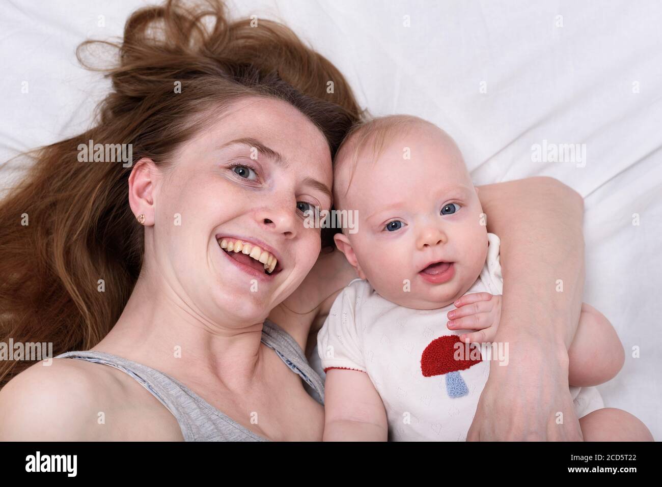 Young mother hugging her little 3 months old daughter. Portrait of smiling mom and child Stock ...