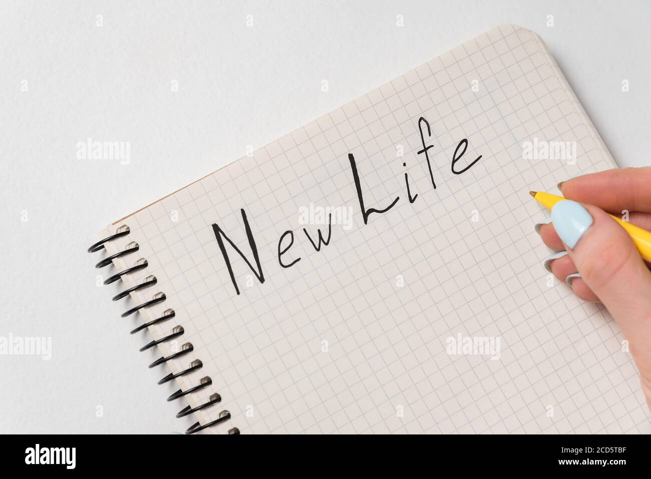 Words New life in Notepad. Female hand writing in notebook. Handwritten ...