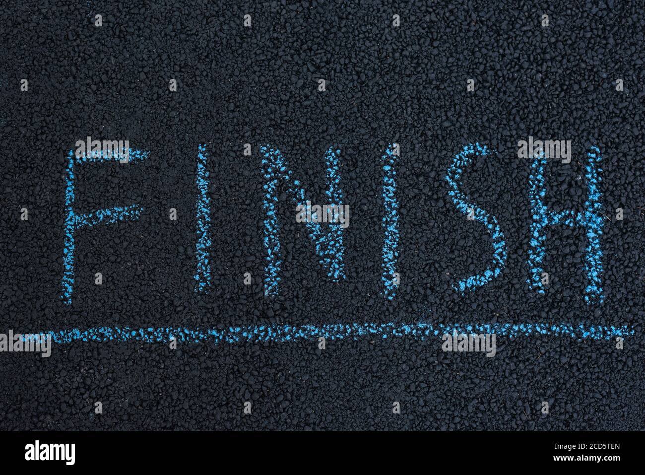 Word FINISH is written in chalk on asphalt. Inscription on the pavement ...