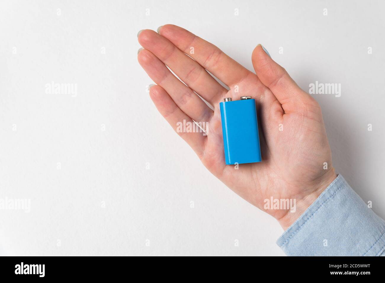 Blue PP3 battery lying on womens palm. Accumulator on white background ...