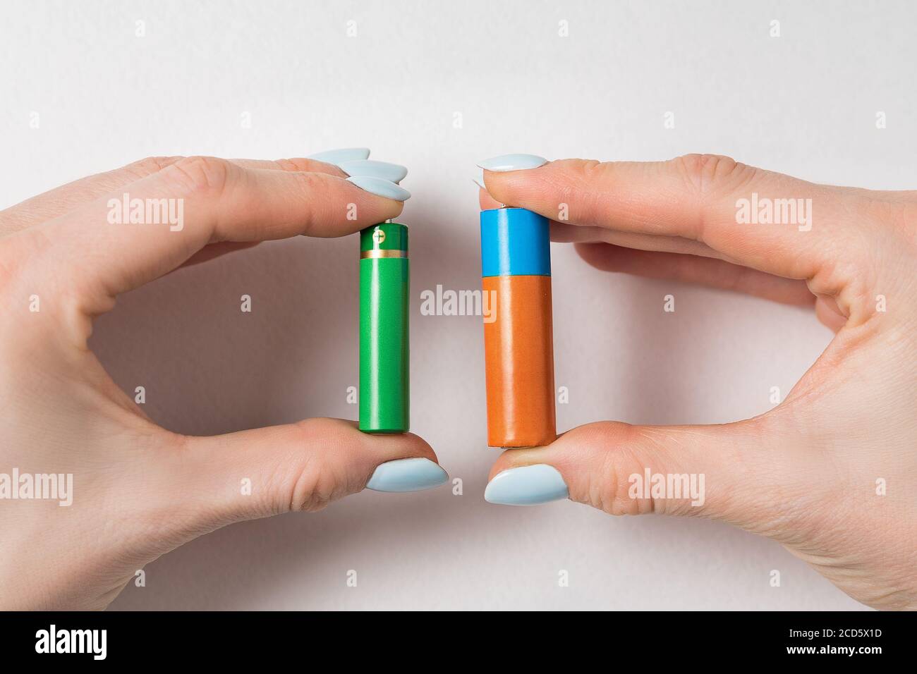Two generic AA and AAA batteries in hands. Generic accumulators on ...