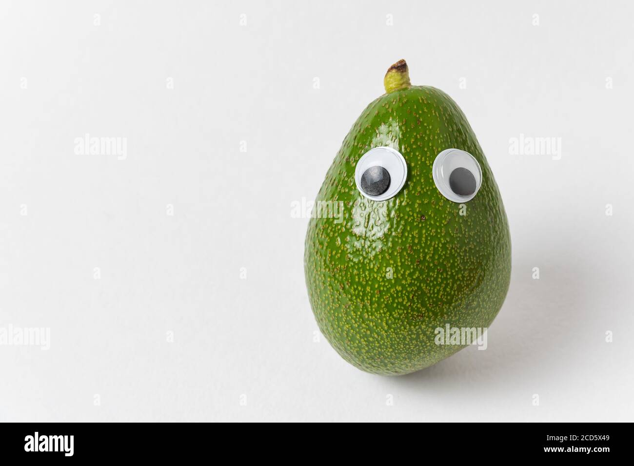 Funny avocado with Googly eyes on white background. Diet proper ...