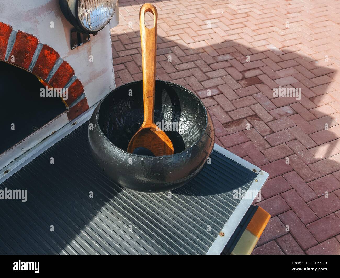 An old Russian cast-iron pot with a wooden spoon stands on the stove ...