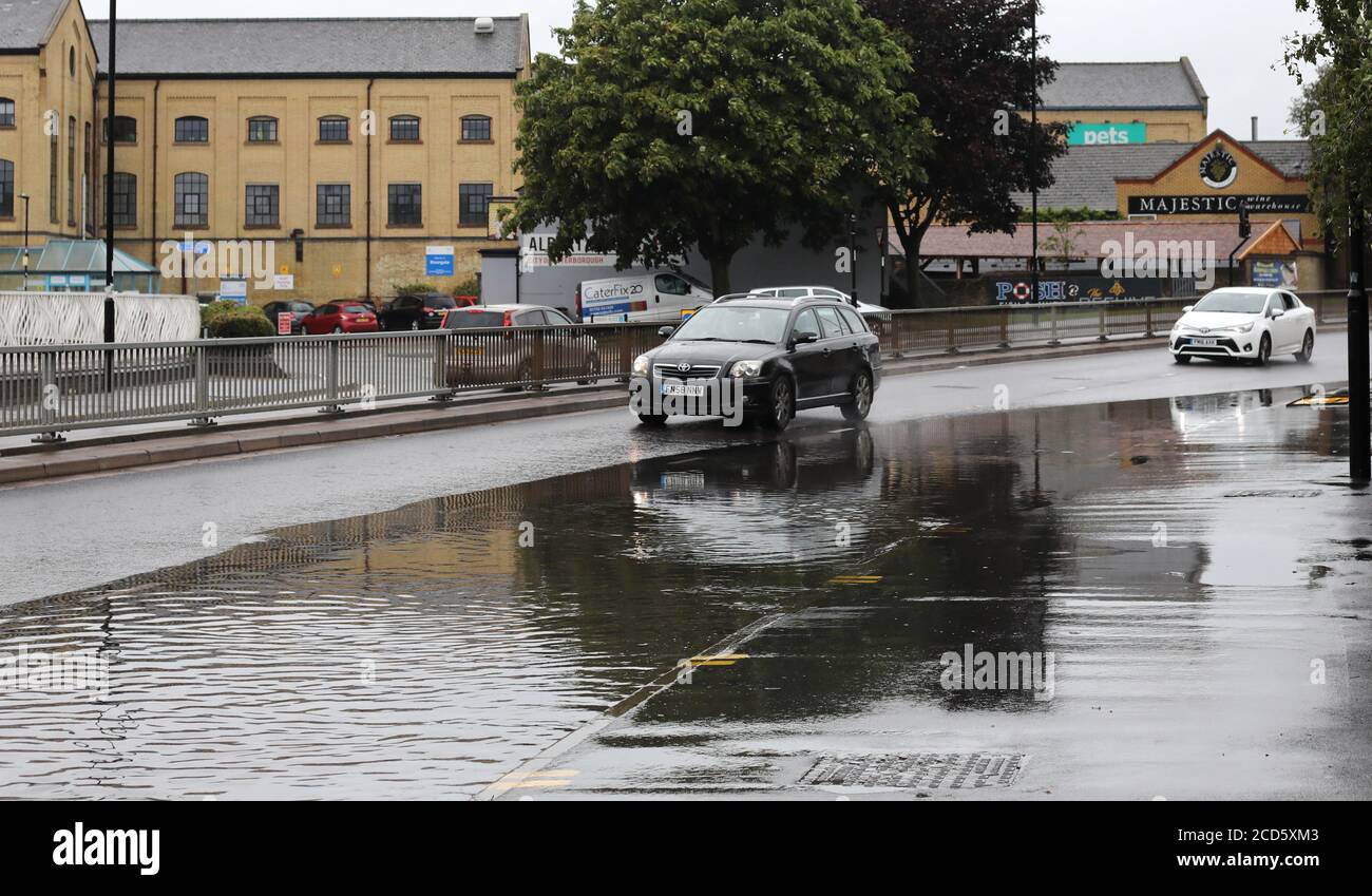 Peterborough, UK. 25th Aug, 2020. Cars battle through a semi-flooded ...