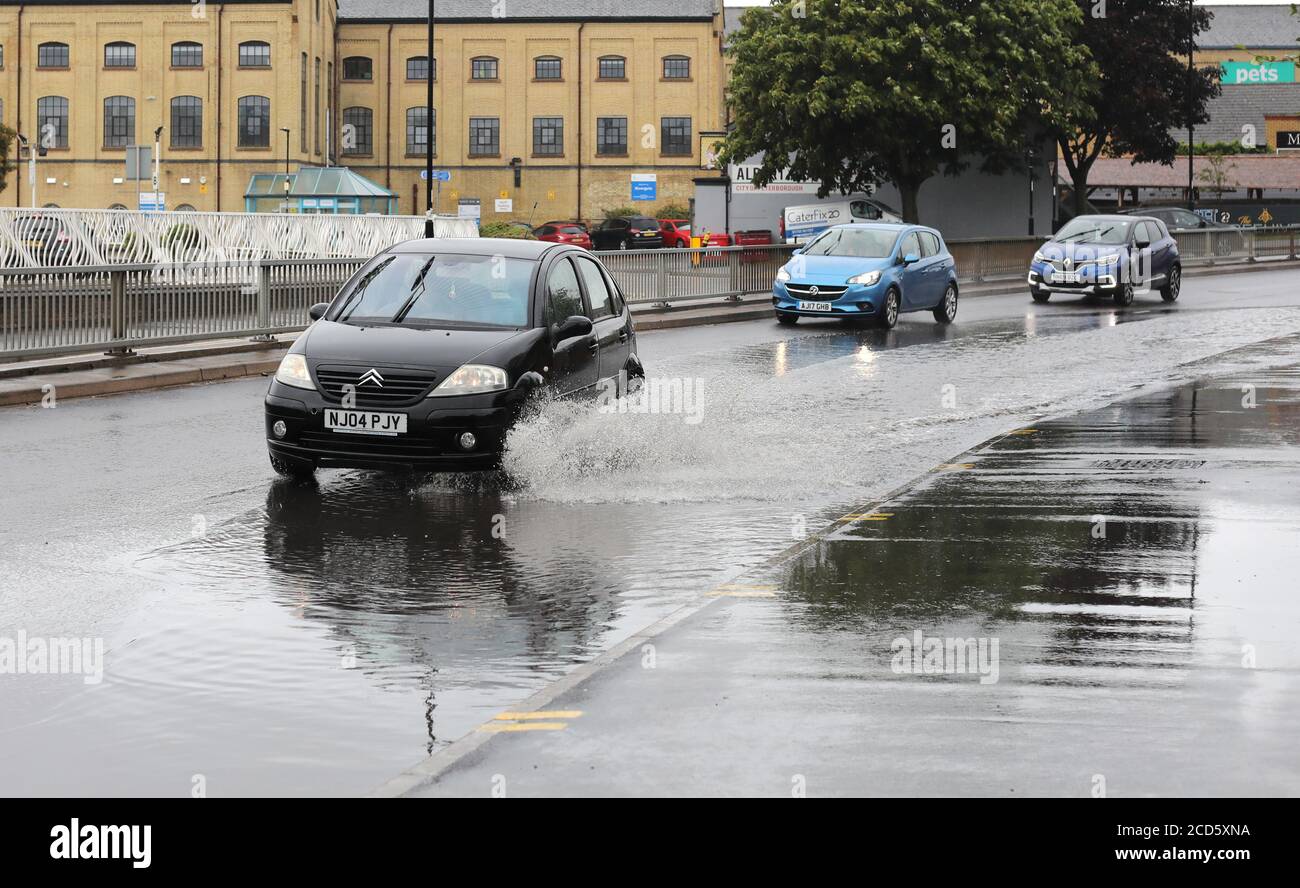 Peterborough, UK. 25th Aug, 2020. Cars battle through a semi-flooded ...