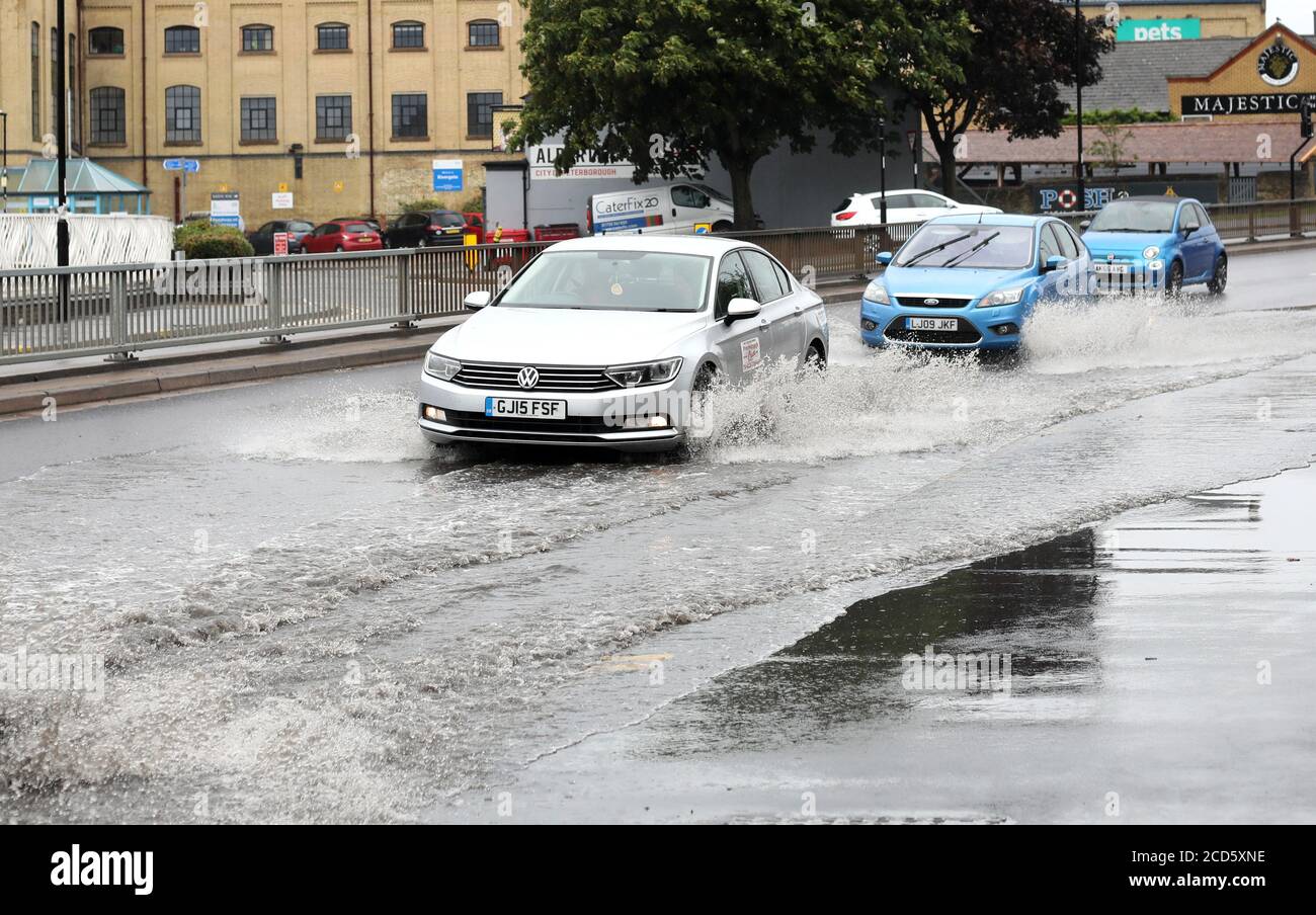 Peterborough, UK. 25th Aug, 2020. Cars battle through a semi-flooded ...